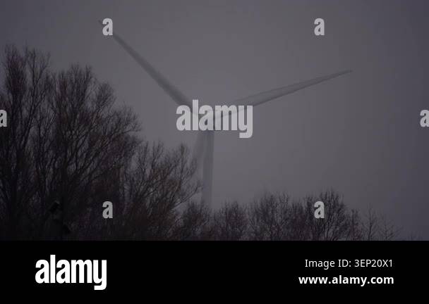 Wind turbine among trees in foggy weather Stock Video Footage - Alamy