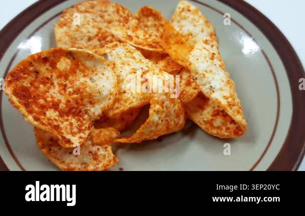 A close-up motion shot of spicy seasoned potato chips resting on a ...