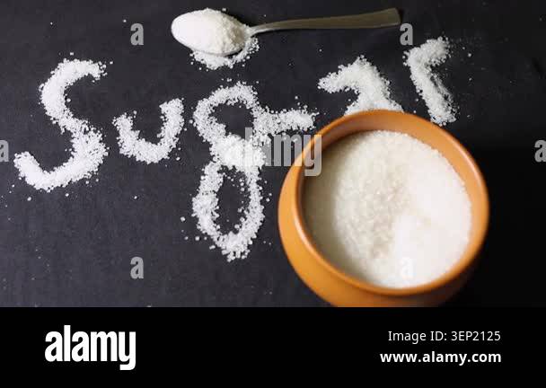 sugar text made from granulated sugar crystals with bowl and spoon on ...