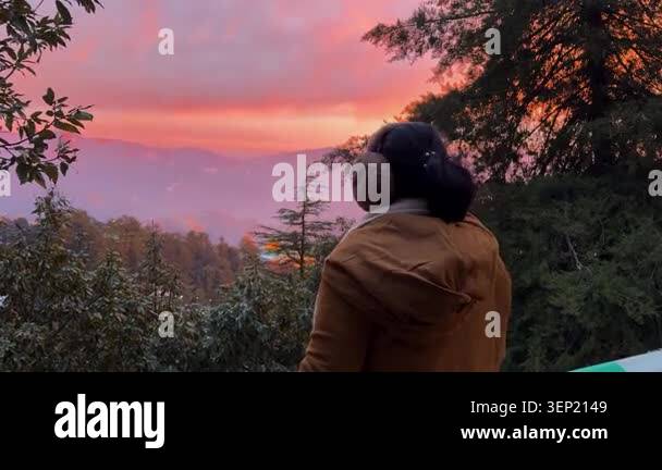 solo traveler enjoying breathtaking sunset over misty mountains and ...