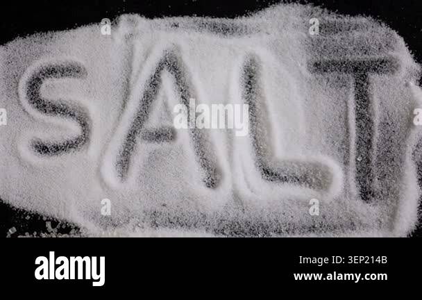 salt crystals spelling word salt on dark background with seasoning ...