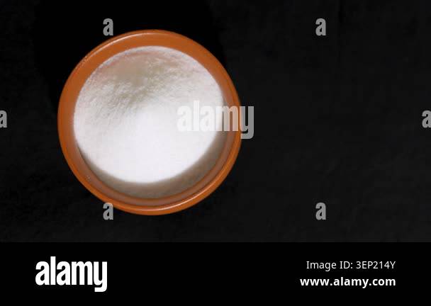 white table salt in rustic clay bowl isolated on black background Stock ...