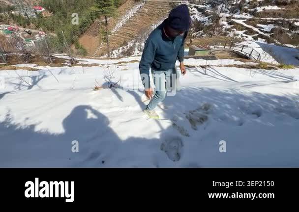 man walking through fresh mountain snow on scenic winter hillside ...
