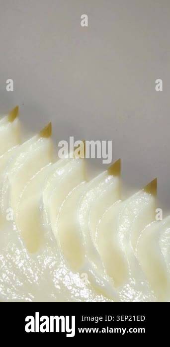 Close-up macro view of thick cream hair mask texture being swatched and ...