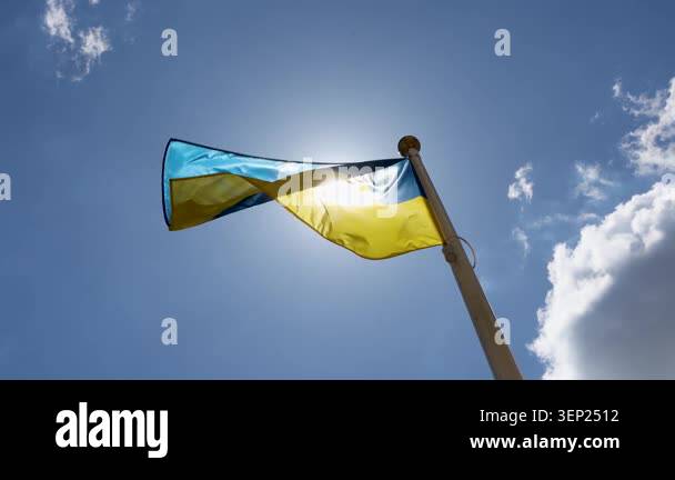 Ukrainian flag waving on flagpole against blue sky and bright sun Stock ...