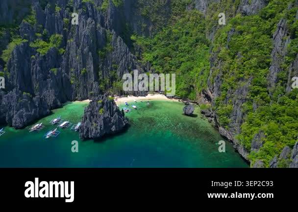Secret lagoon hidden by towering limestone cliffs, clear turquoise ...