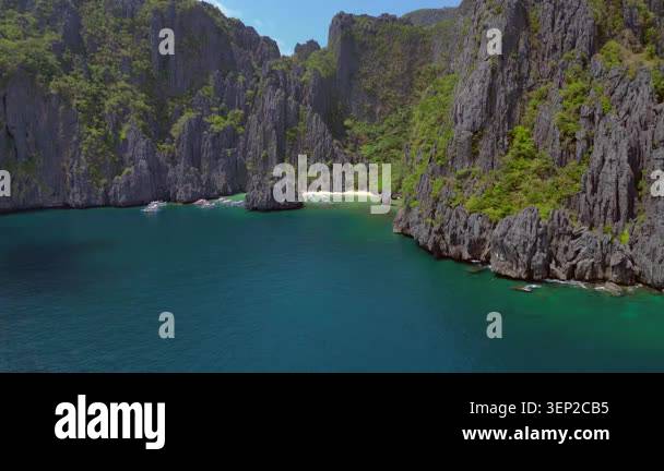 Secret lagoon hidden by towering limestone cliffs, clear turquoise ...