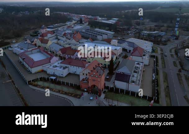 Aerial view capturing a large shopping outlet center with multiple ...