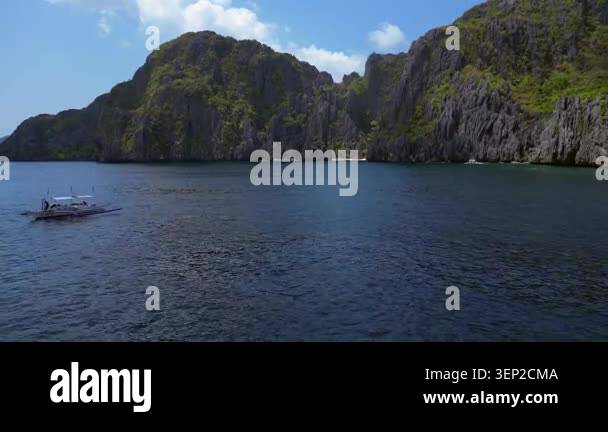 Secret lagoon hidden by towering limestone cliffs, clear turquoise ...