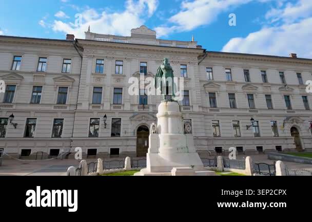 Pecs, Hungary May 1, 2026: Statue monument standing before a historic ...