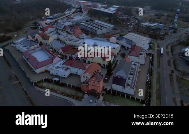Aerial view capturing a large shopping outlet center with multiple ...