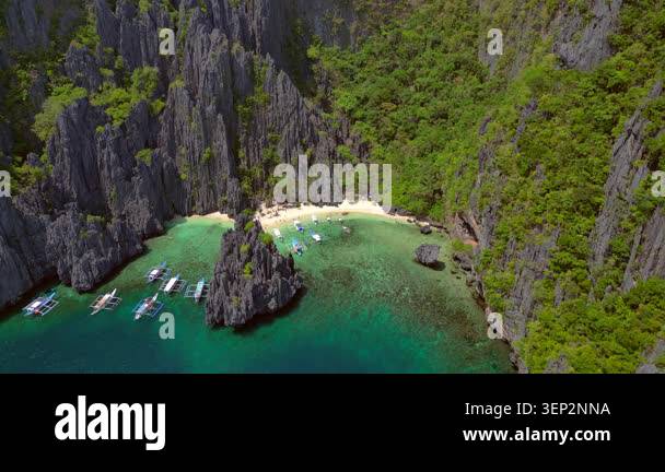 Secret lagoon hidden by towering limestone cliffs, clear turquoise ...