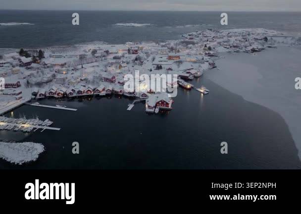 Top-down aerial shot at dusk showing a small coastal fishing village ...
