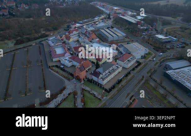 Aerial view capturing a large shopping outlet center with multiple ...