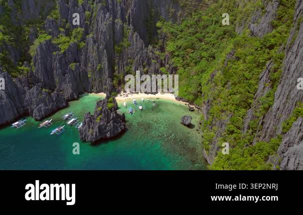 Secret lagoon hidden by towering limestone cliffs, clear turquoise ...