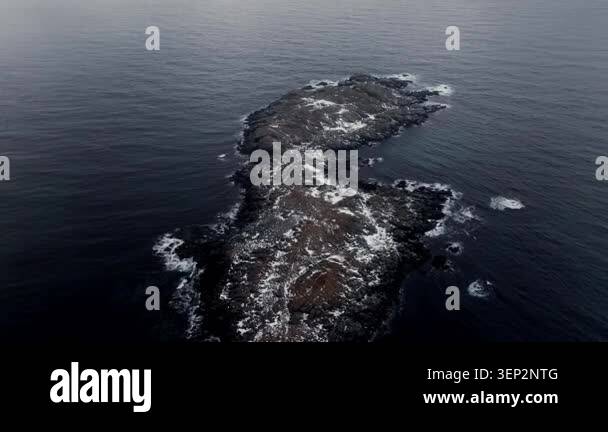 Birds-eye view of a narrow, rocky island extending diagonally across ...