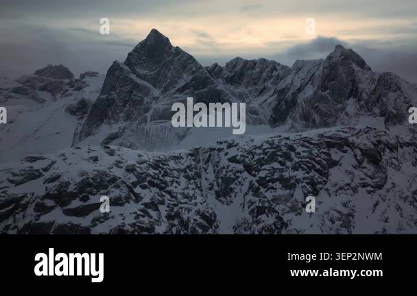 Aerial perspective of a rugged alpine mountain range at dusk featuring ...