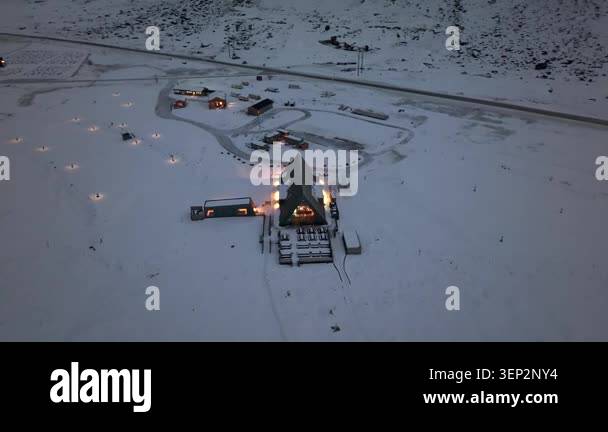 High-angle night shot of a remote snowbound lodge complex illuminated ...