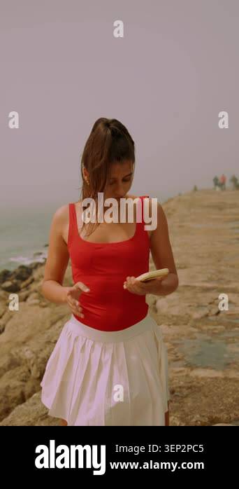 Standing woman on cliff holding cup, arm extended in gesture, scrolling ...