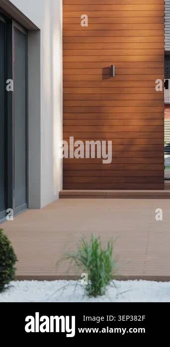 Vertical video. Modern residential building entrance with timber wall ...