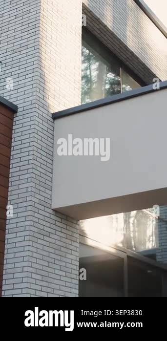 Vertical video. Modern residential building with white brick facade ...