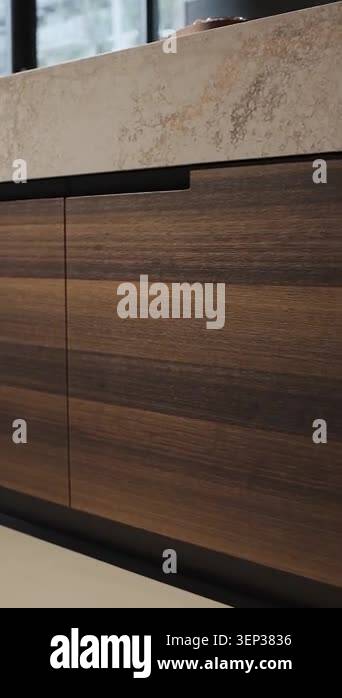 Vertical video. Kitchen island with stone and wood finish, shelves and ...