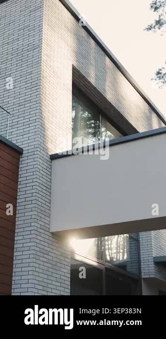 Vertical video. Contemporary house facade with white brick walls, wood ...