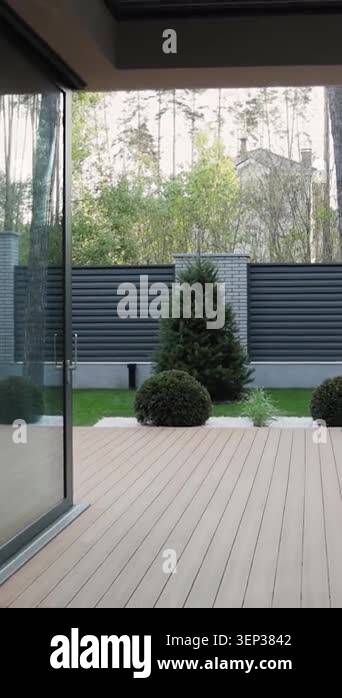 Vertical video. Modern home patio overlooking landscaped garden near ...