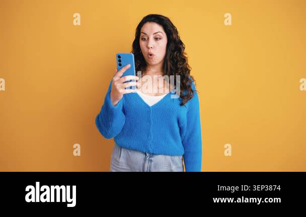 Young woman looking at her smartphone with a sequence of expressions ...