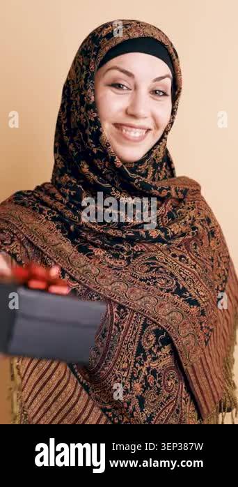 Beautiful young islamic woman wearing a traditional headscarf accepting ...