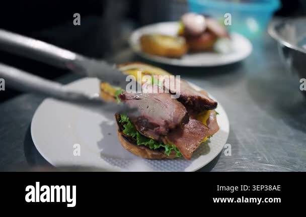 Professional cook carefully assembling delicious sandwiches, placing ...