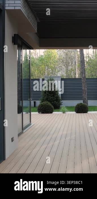 Vertical video. Summer terrace with wooden floor and slatted roof ...