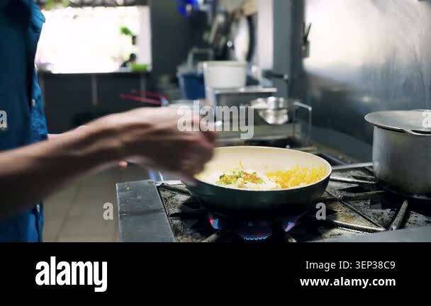 Professional chef preparing a delicious shrimp and rice dish in a ...