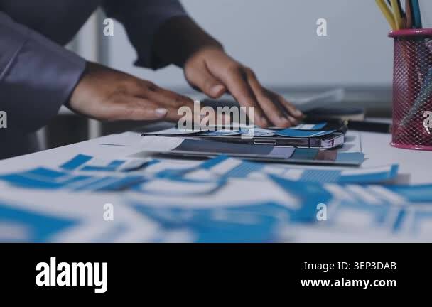 business man hand with a pen and pen on the background of office table ...