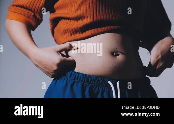 a young girl with a white t - shirt shows her belly. the concept of a ...