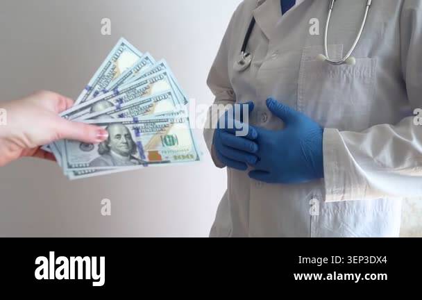 Close-up of doctor in white coat and blue gloves receiving or hiding ...
