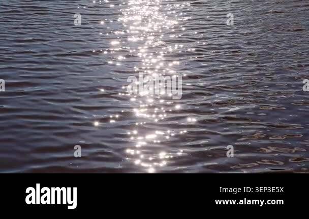 Slow Motion Calm water surface glimmering and reflecting the bright sun ...