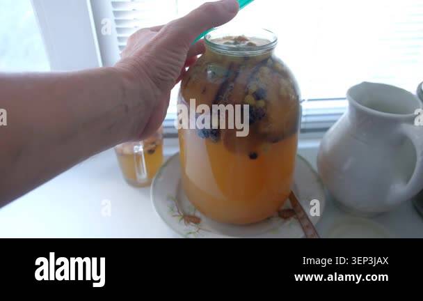 a glass of juice with a jar of fruit Stock Video Footage - Alamy