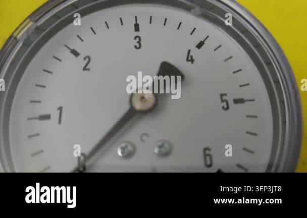Macro pan shot of a round mechanical pressure gauge dial indicator with ...