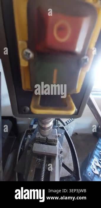Finger pressing the green start button on a heavy-duty industrial drill ...