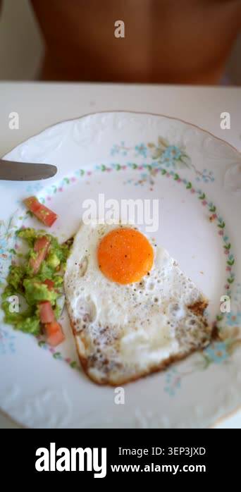 Close-up of a simple homemade breakfast plate with fried egg, avocado ...