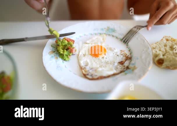 Close dining scene showing hands using a fork and knife to eat a ...