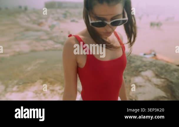 Woman red swimsuit beach candid movement, sunglasses flicking hair ...