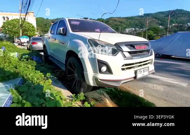 Sporty pickup truck parked in tropical Thai city surrounded by palm ...