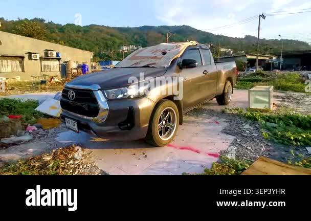 Sporty pickup truck parked in tropical Thai city surrounded by palm ...