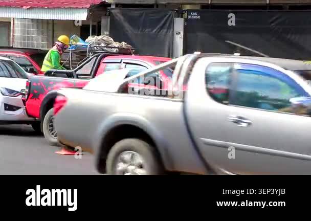 Sporty pickup truck parked in tropical Thai city surrounded by palm ...