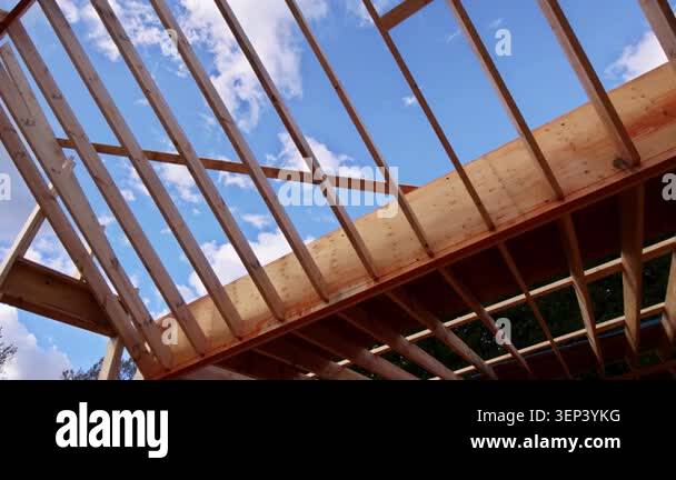 Construction workers make progress on house with wooden beams rafters ...