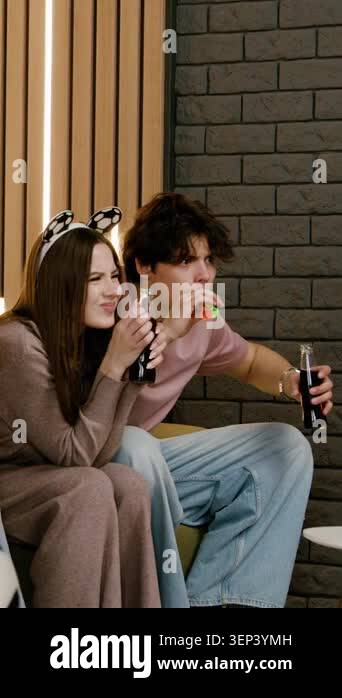 Young Caucasian man and woman engaged in watching a screen, showing ...