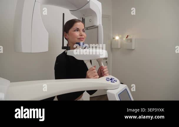 Female patient standing still for a panoramic dental x-ray using an ...