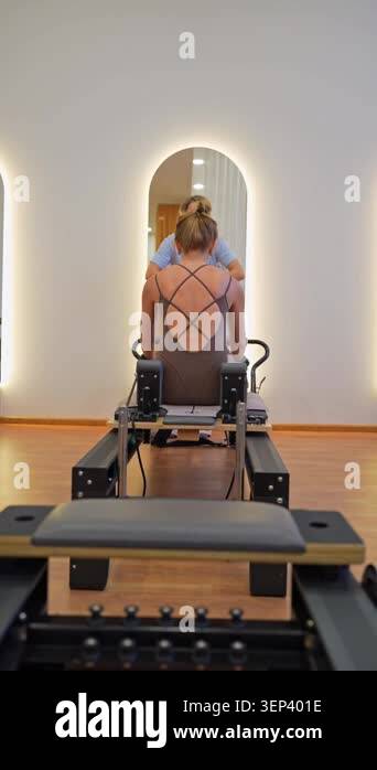 A woman in activewear does pilates exercises for the chest and back ...